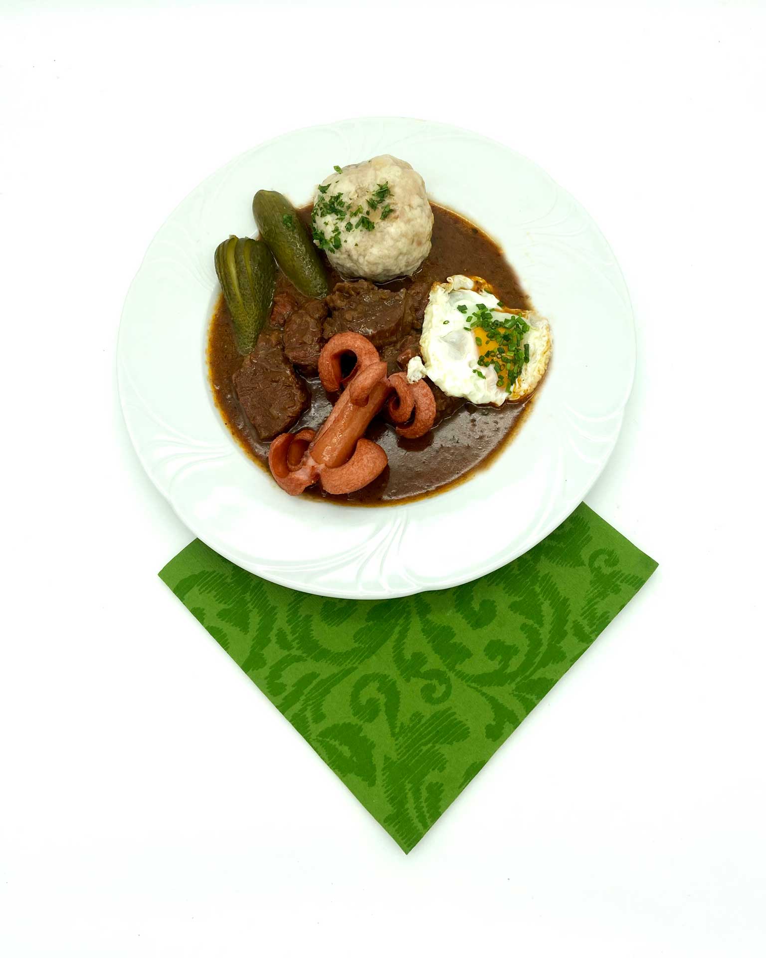 Fiakergulasch mit Spiegelei, Gurkerl, Würstel und Semmelknödel ...